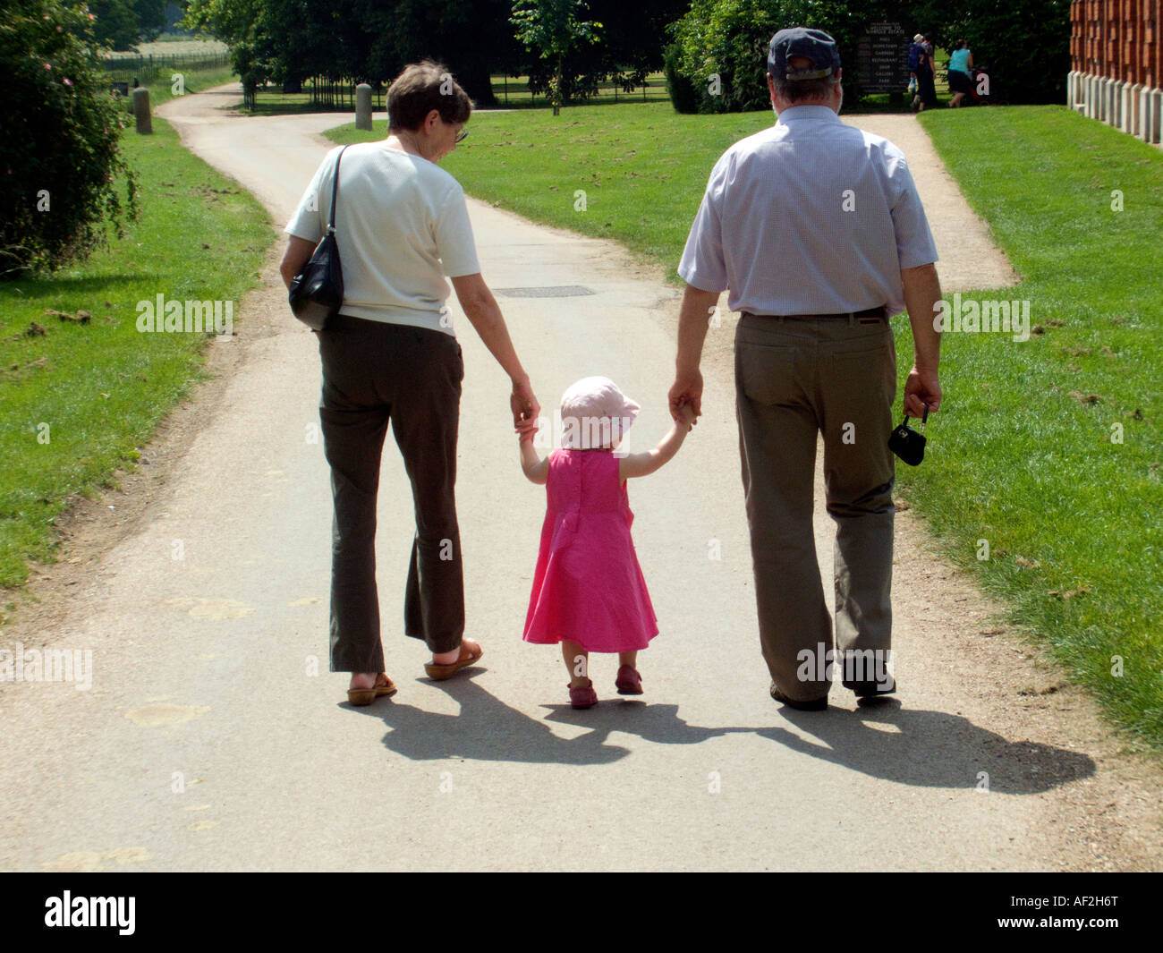 Child walking with grand parents Stock Photo - Alamy
