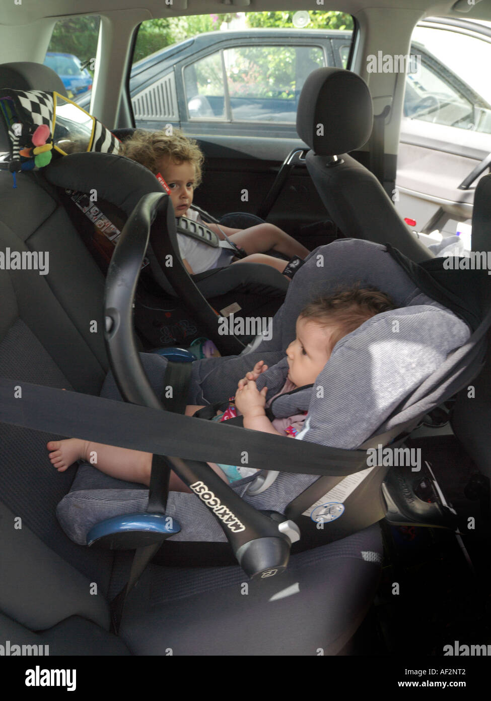 Children in Forward and Rear Facing Car Seats in Back of Car Stock ...