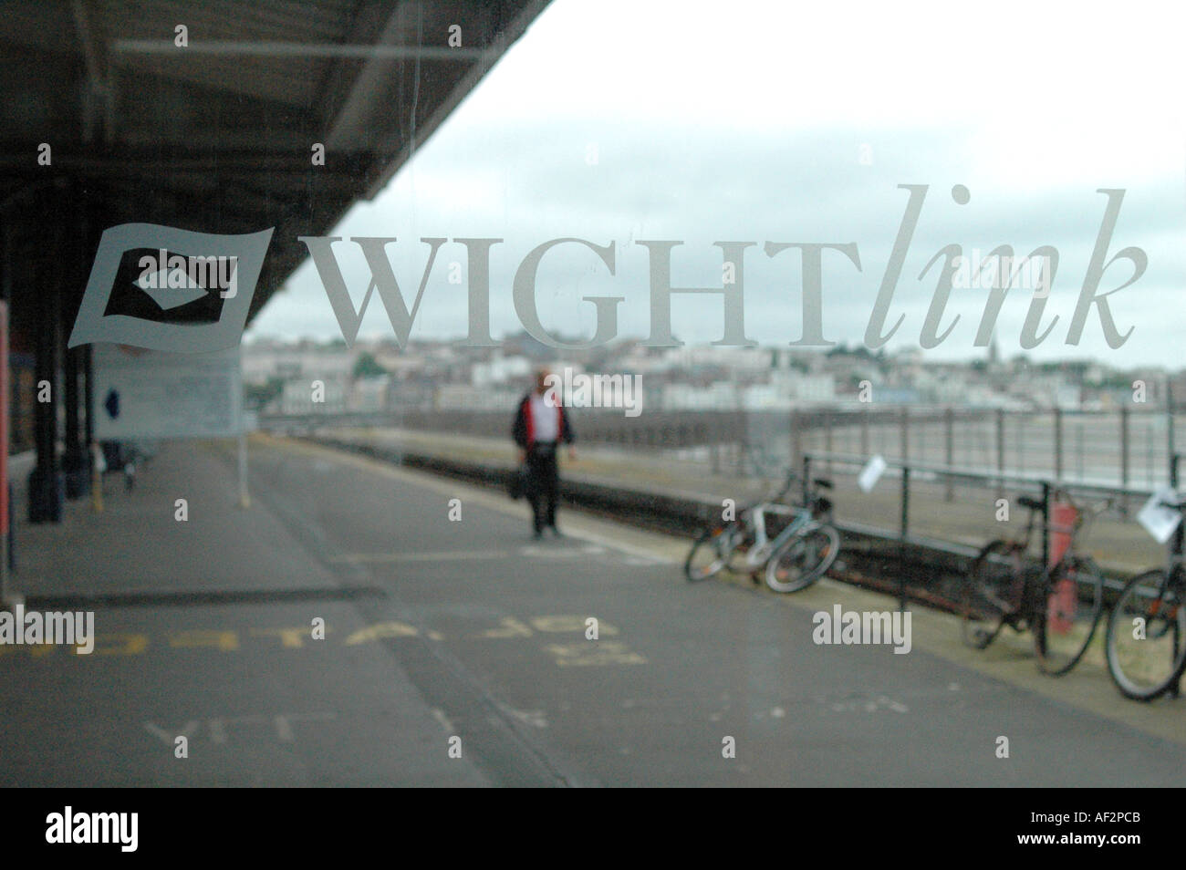View through window of man waiting on platform at Wightlink ferry ...