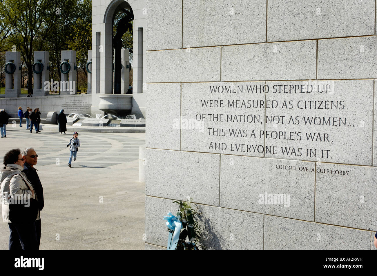 Tourists reading inscription on World War II Memorial in Washington DC ...