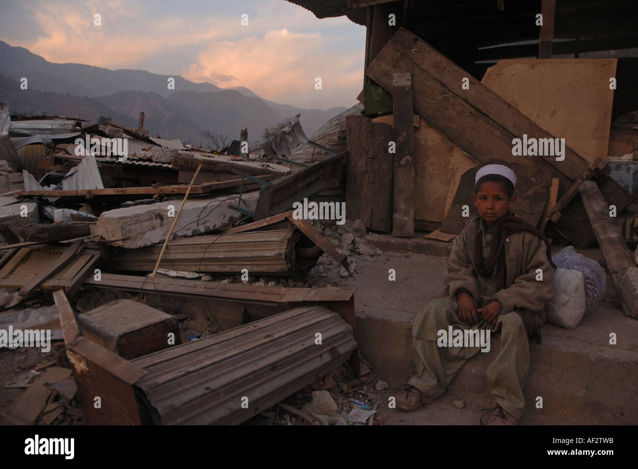 A boy sits among the destroyed city of Balakot after a 7.6 magnitude ...