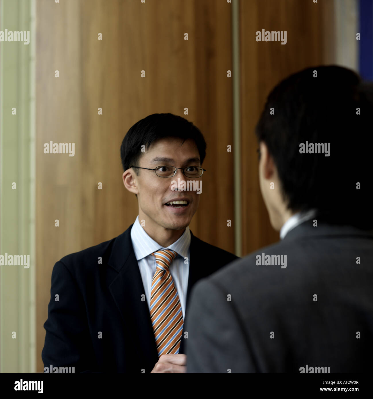 Businessmen talking, over the shoulder view Stock Photo - Alamy