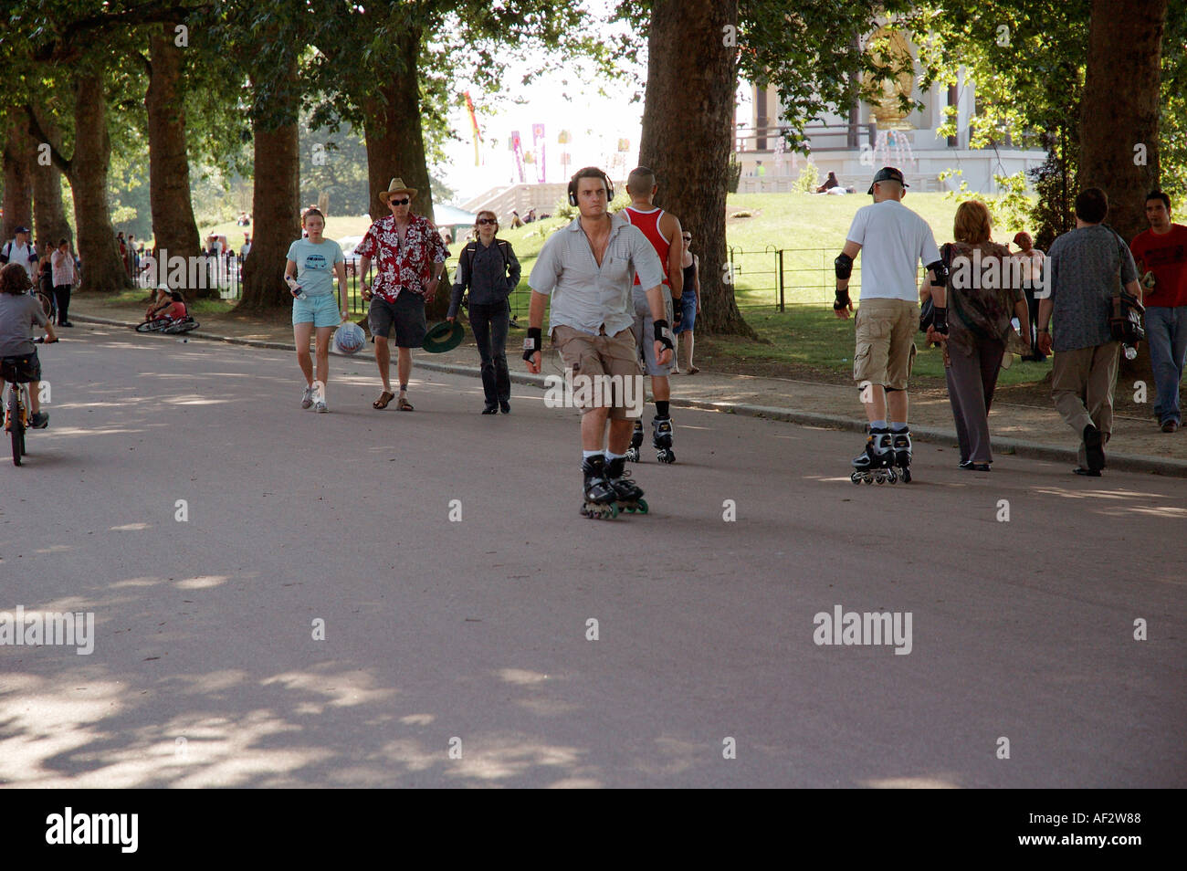 Park scene with people rollerblading walking Stock Photo - Alamy