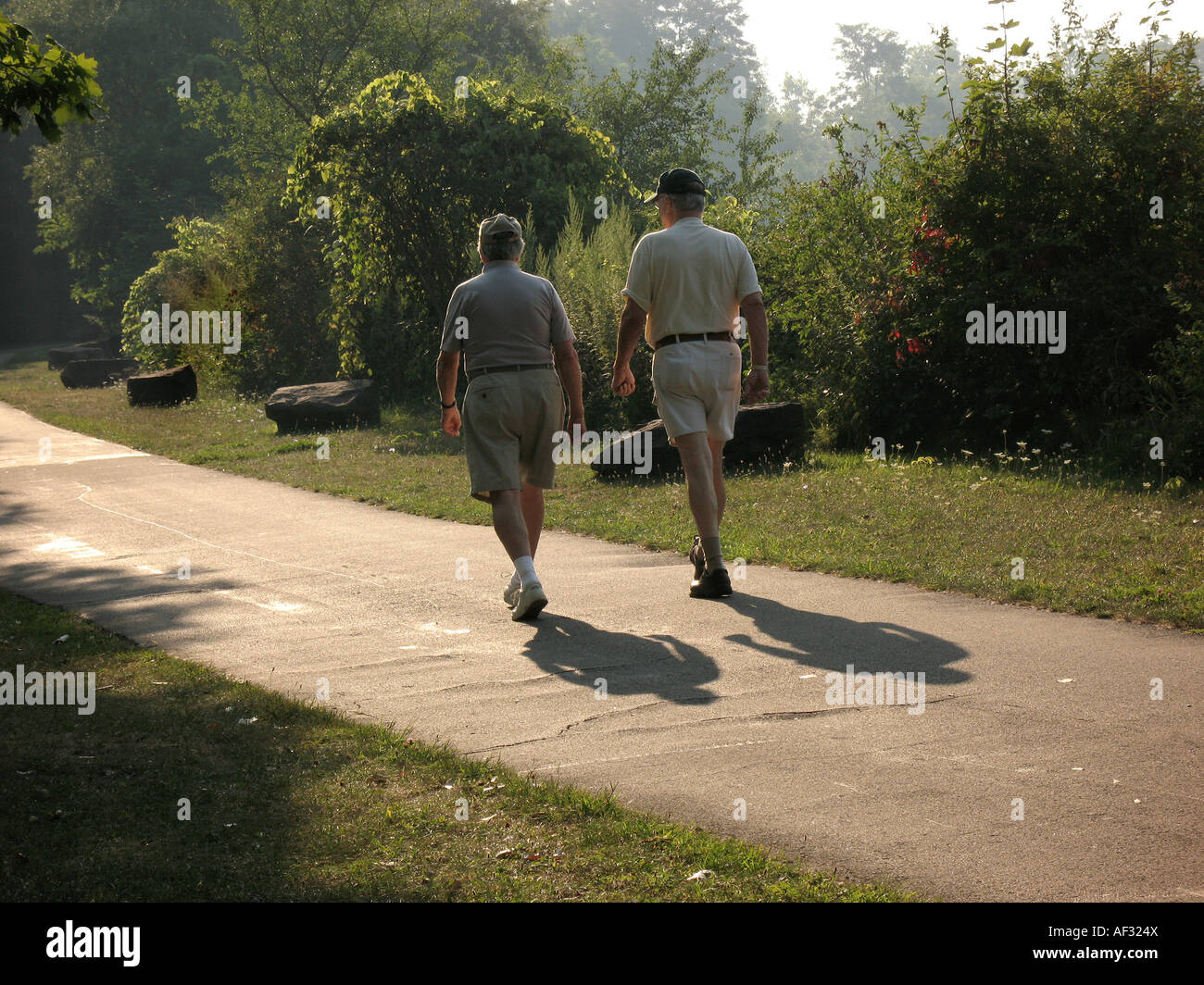 Two man walking on park path Stock Photo - Alamy