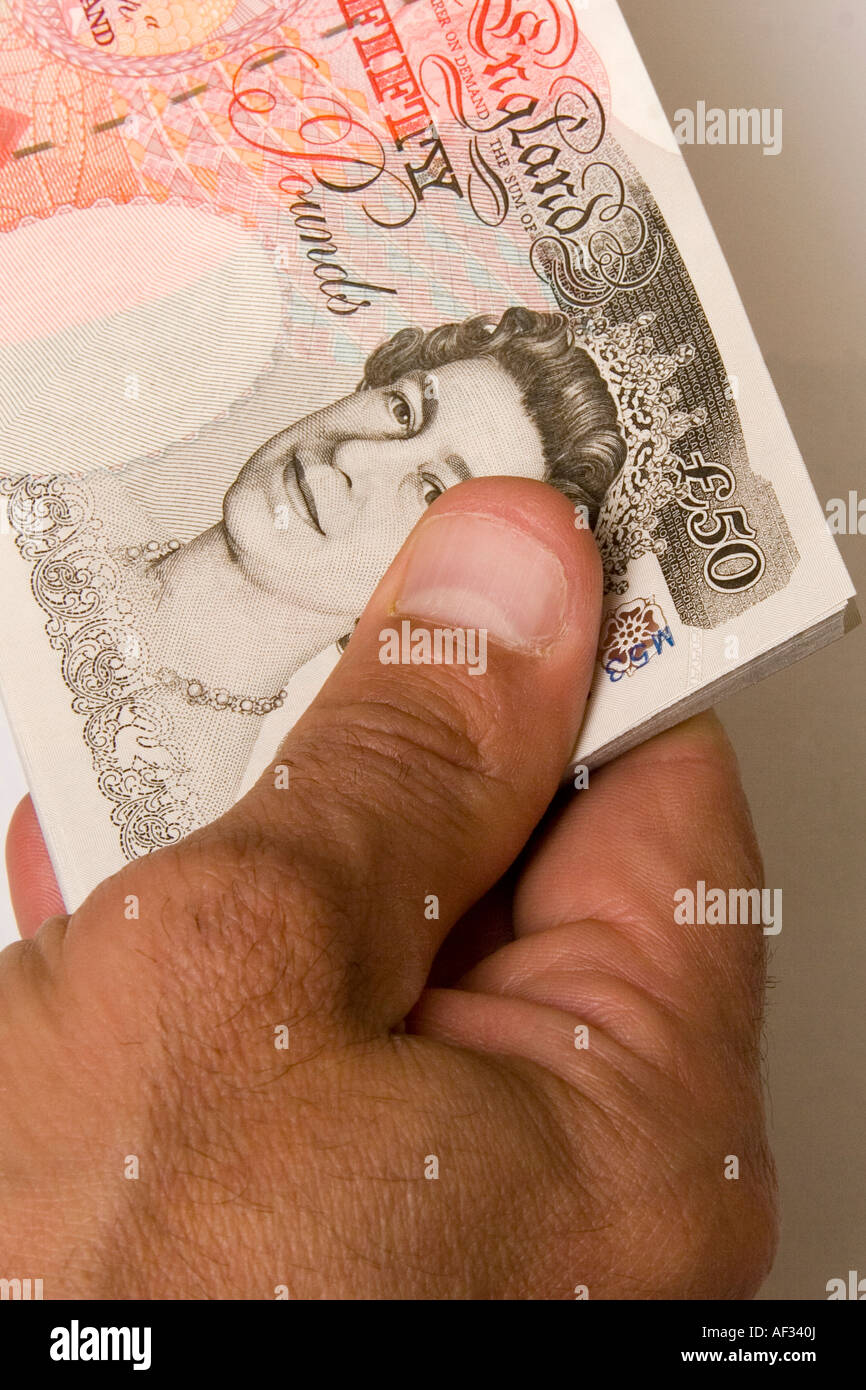 A man holding five thousand in cash in new fifty pound notes in his ...