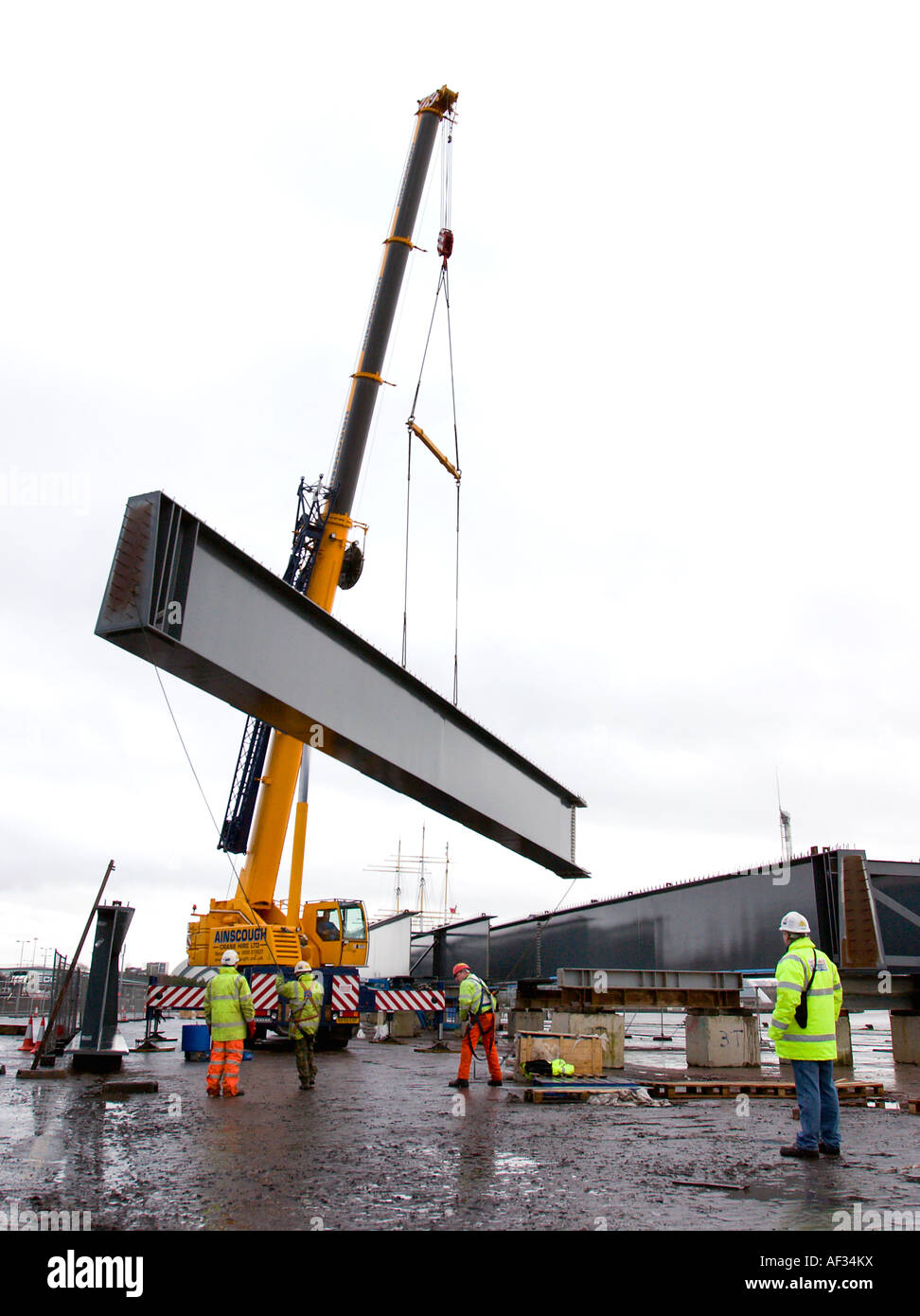 Construction workers guiding large steel structure. © Copyright Carsten ...