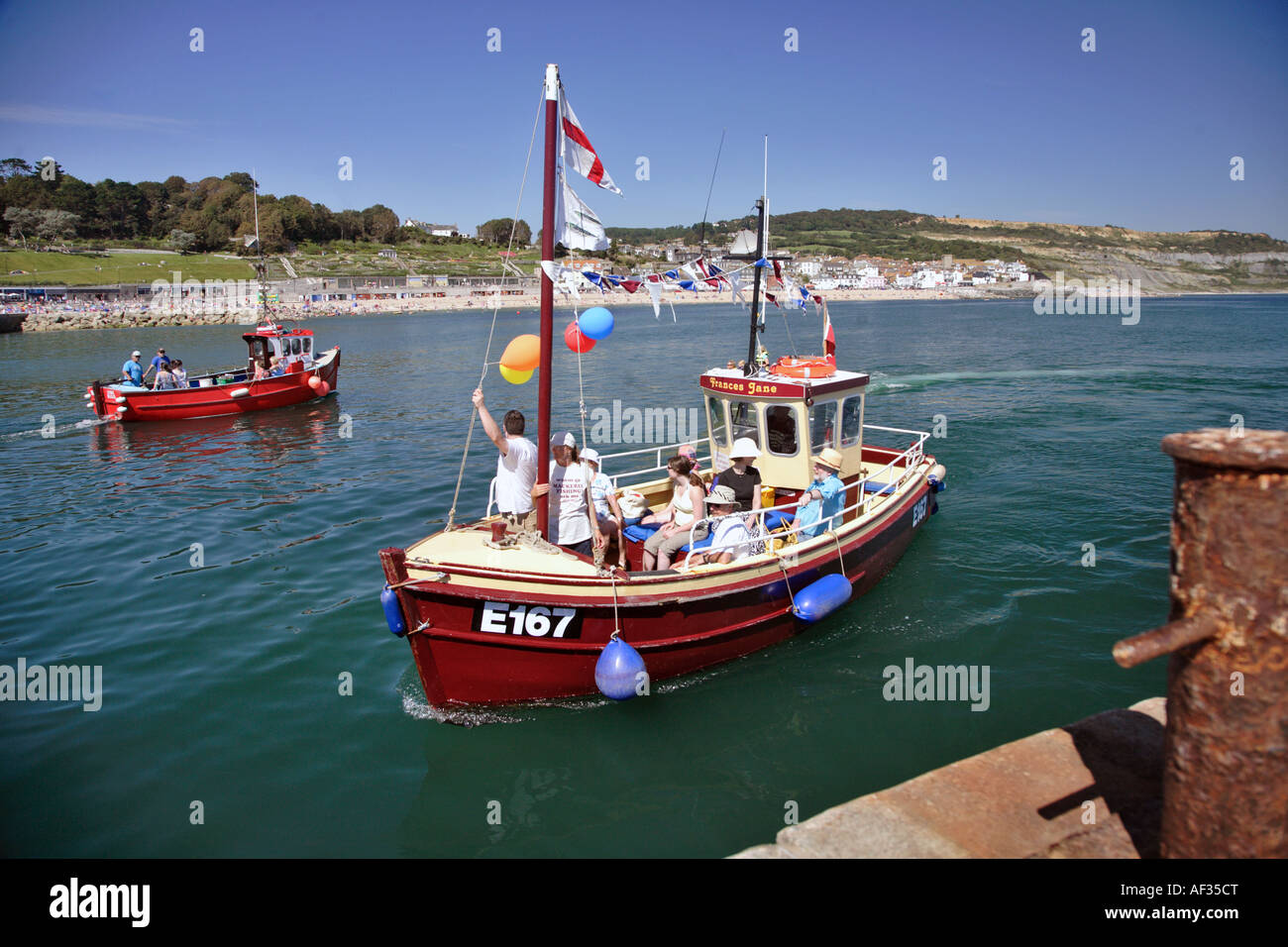 a small fishing boat comes into harbour in Lyme Regis, Dorset, england ...