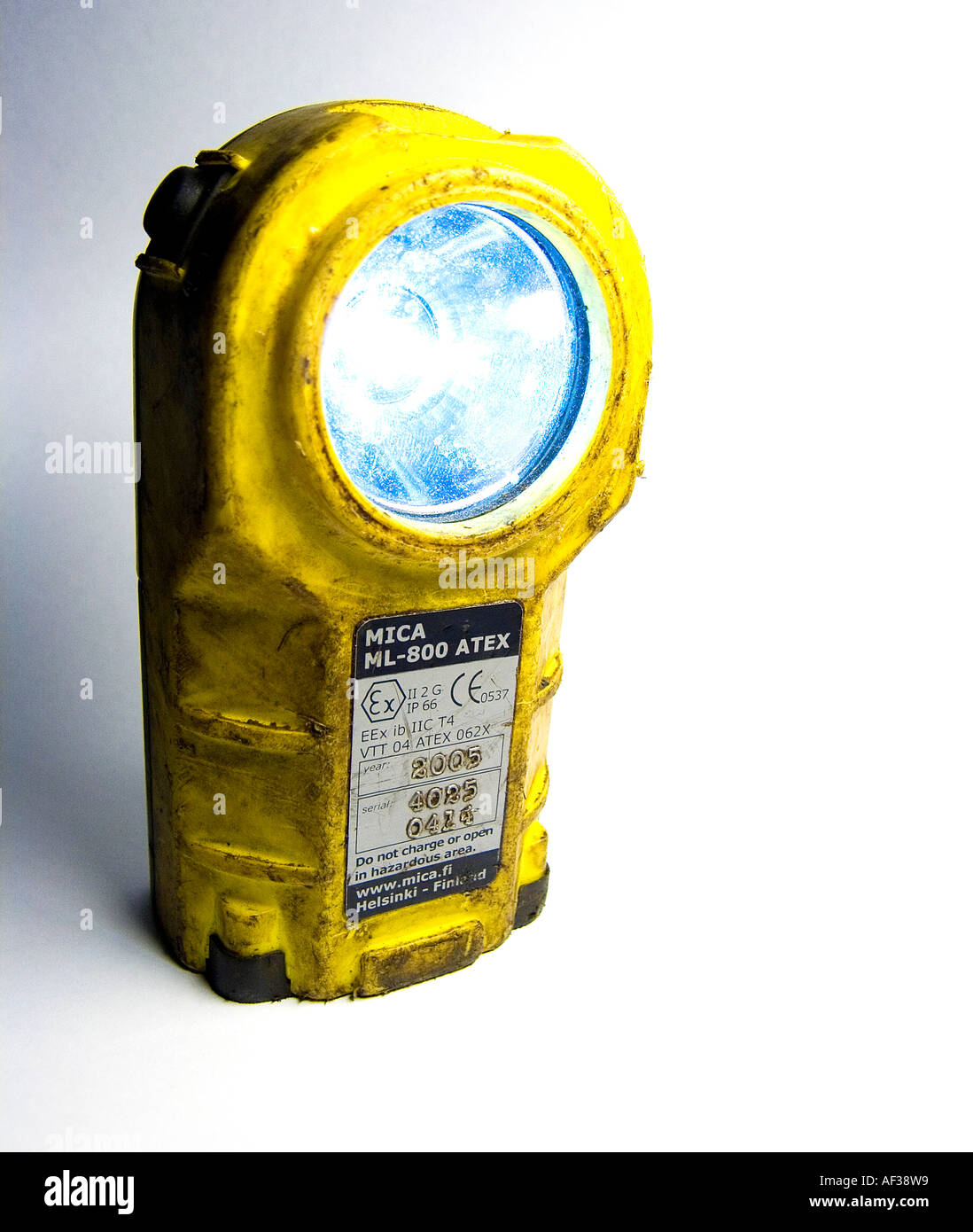An industrial yellow torch with light shining against a white ...