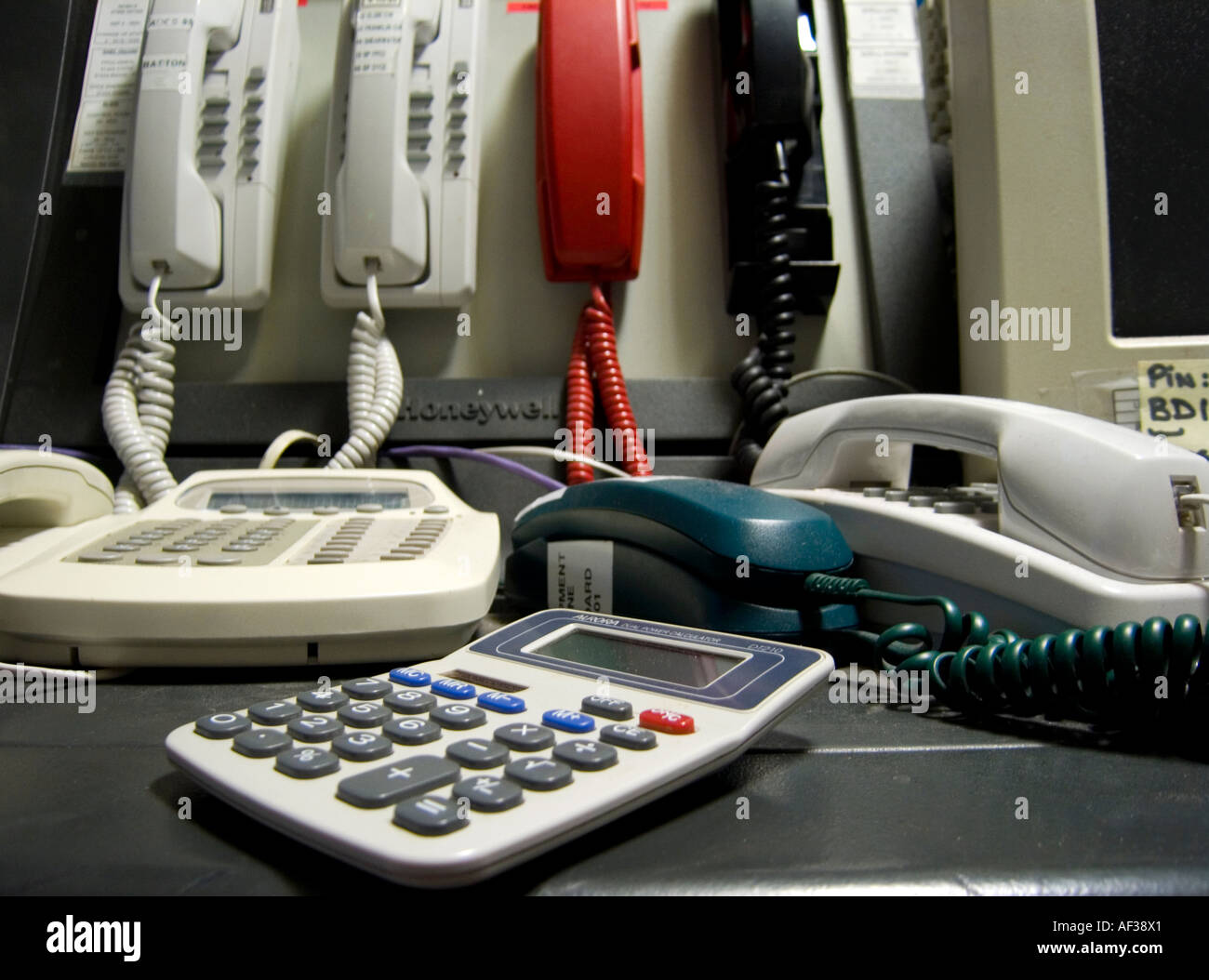 A communications panel with multiple telephones and a calculator in the ...