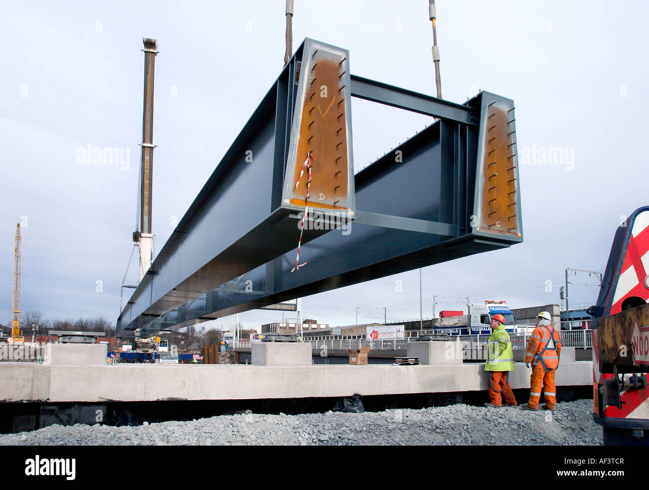 Construction workers positioning large steel structure. © Copyright ...