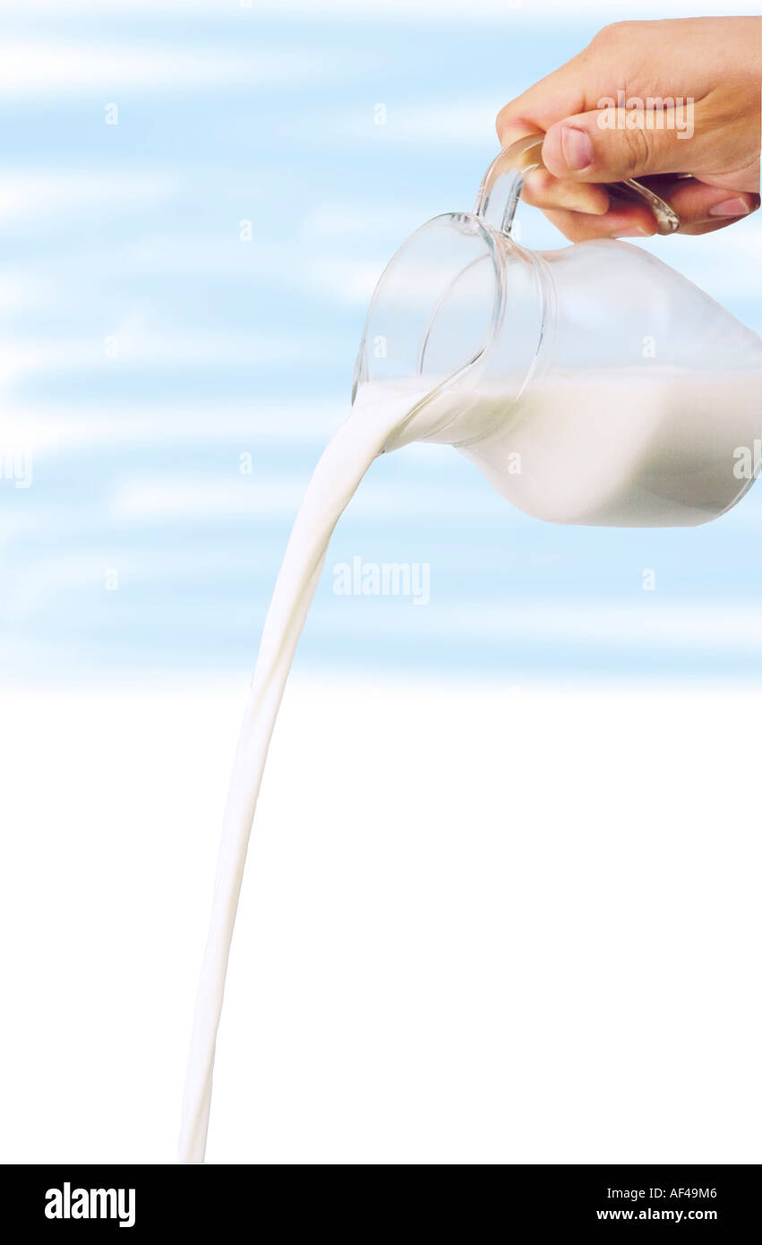 Milk pouring from glass jug Stock Photo - Alamy