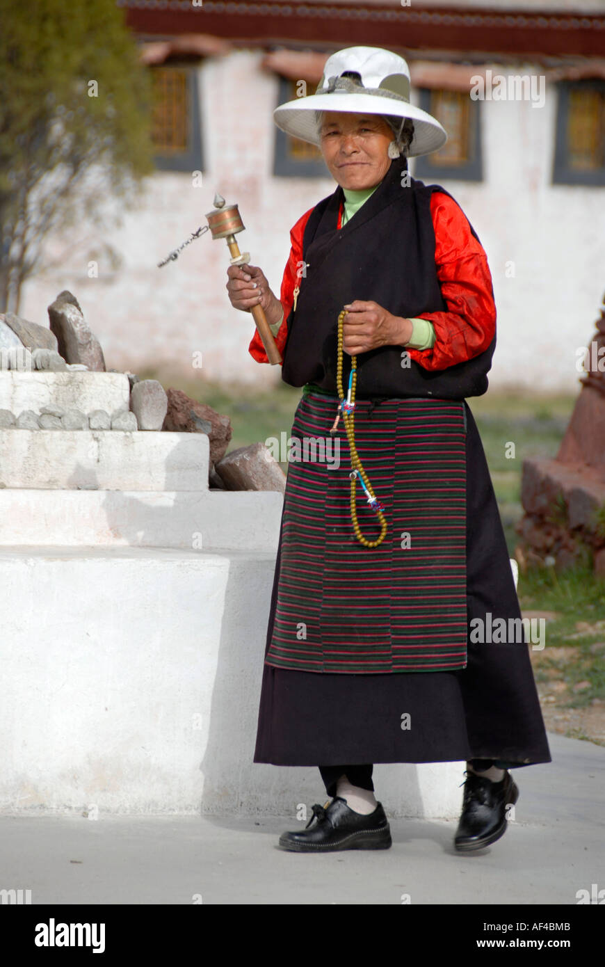 Tibetan pilgrim with prayer wheels in her hand Samye Monastery Tibet ...