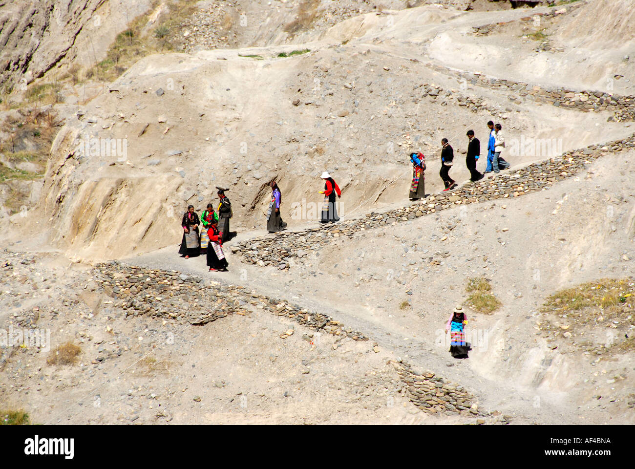 Tibetan Pilgrims in traditional dress on a zigzag path Pelkor Chöde ...