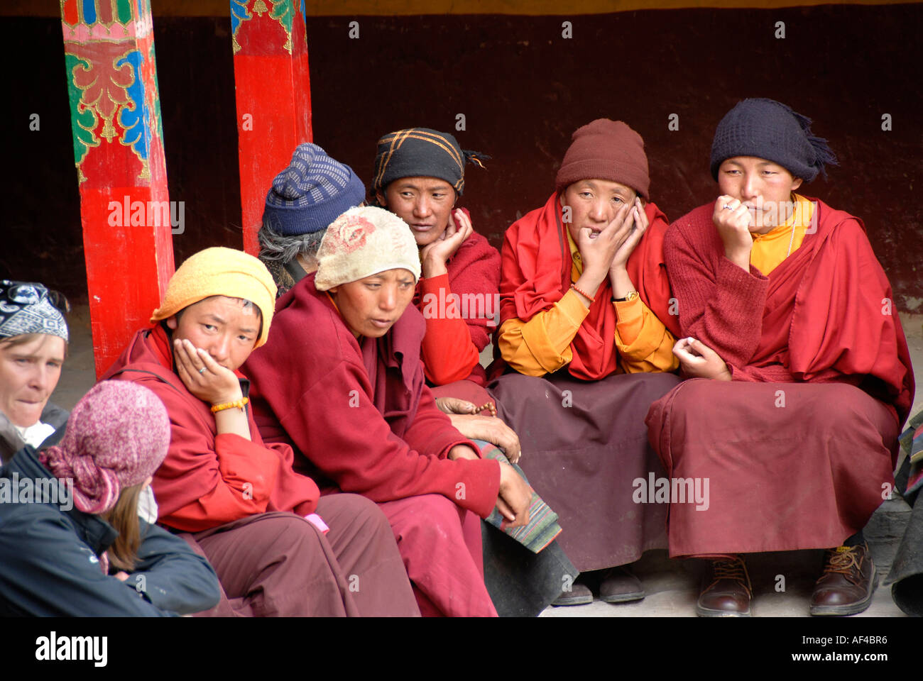 MR Tibetan nuns in red robes sit side by side Rongbuk Monastery Tibet ...