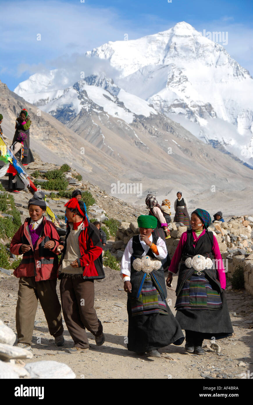 Tibetan pilgrims in traditional dress in front of Mt Everest at Rongbuk ...