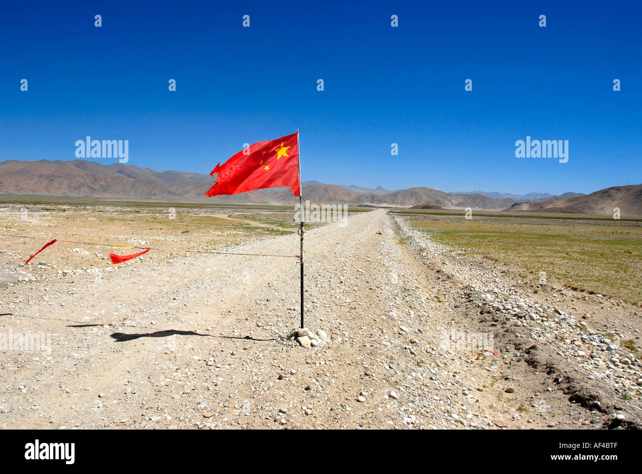 Chinese flag waves on dirt road at checkpoint Old Tingri Tibet China ...