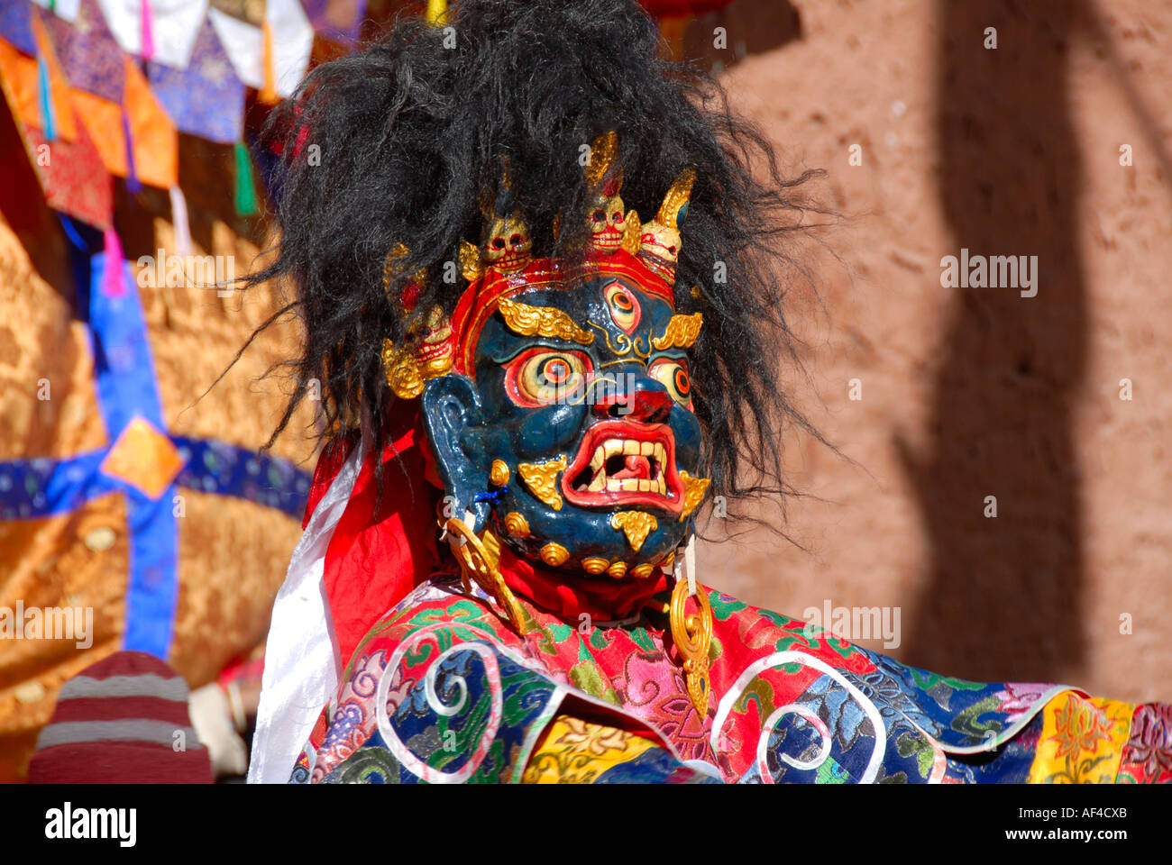 Monk wears fearful and blue mask of a demon at festival in colourful ...