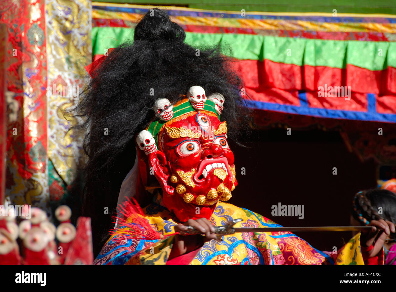 Monk wears fearful and red mask of a demon at festival in colourful ...