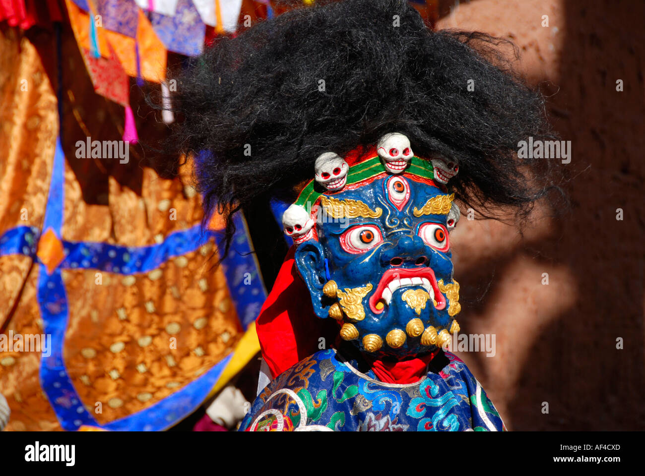 Monk wears fearful and blue mask of a demon at festival in colourful ...