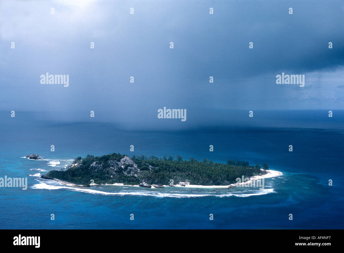 Aerial view of rain storm over the sea with local uninhabited island in ...