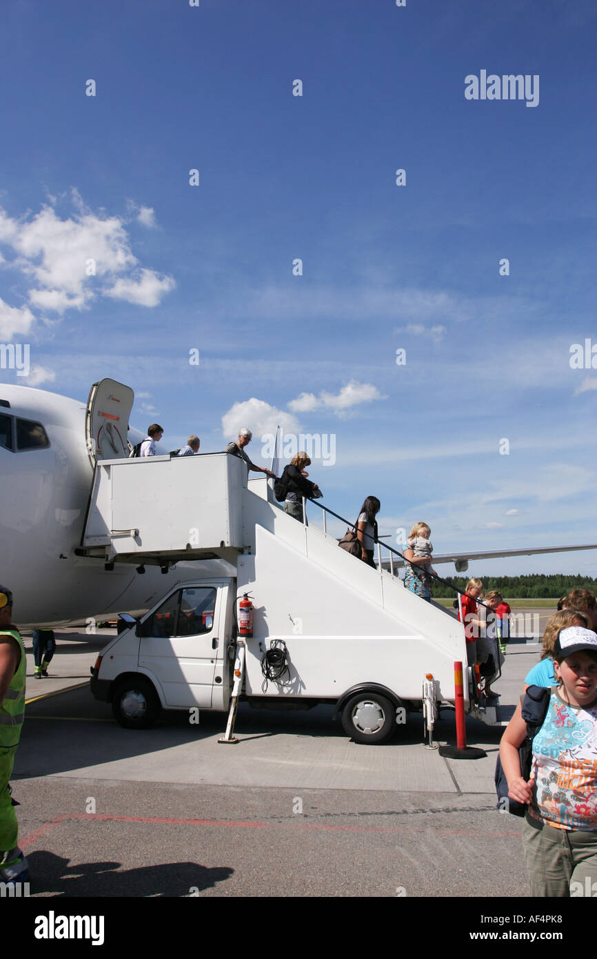 Passengers exiting an airplane at an airport Stock Photo - Alamy
