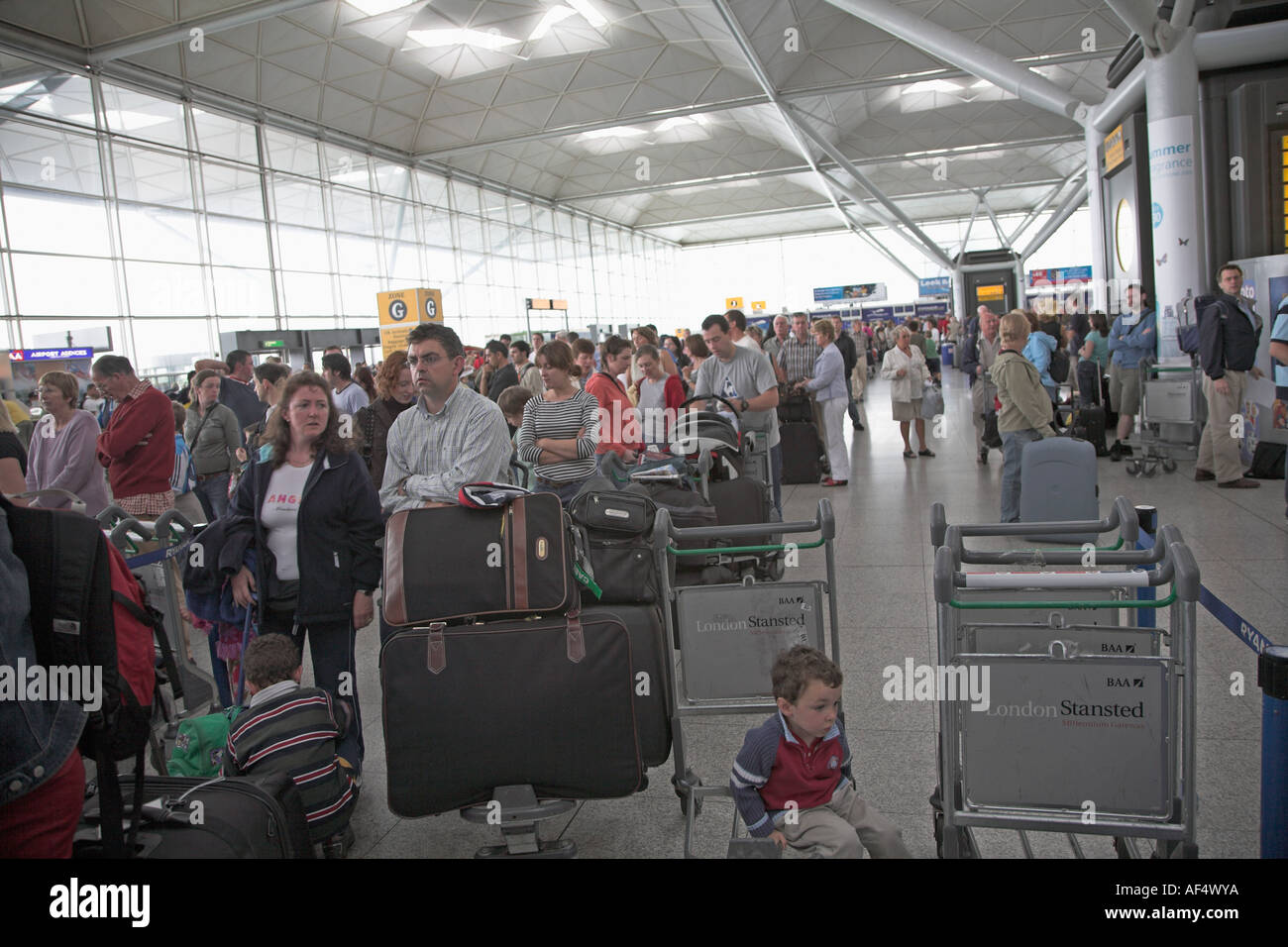 People queuing at check in Stansted airport England Stock Photo - Alamy
