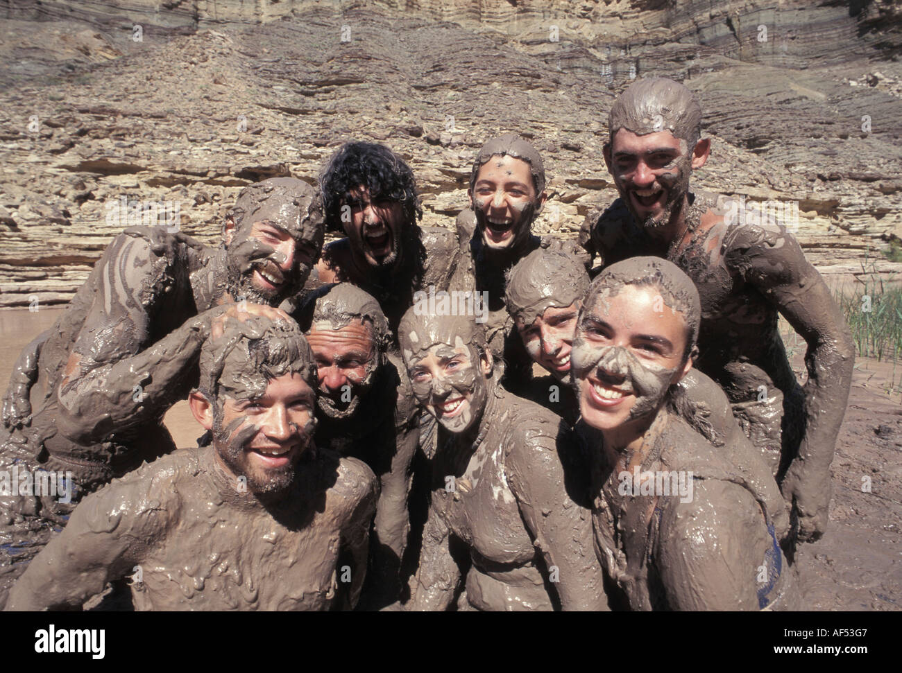 Close-up of a group of people covered with mud smiling Stock Photo - Alamy