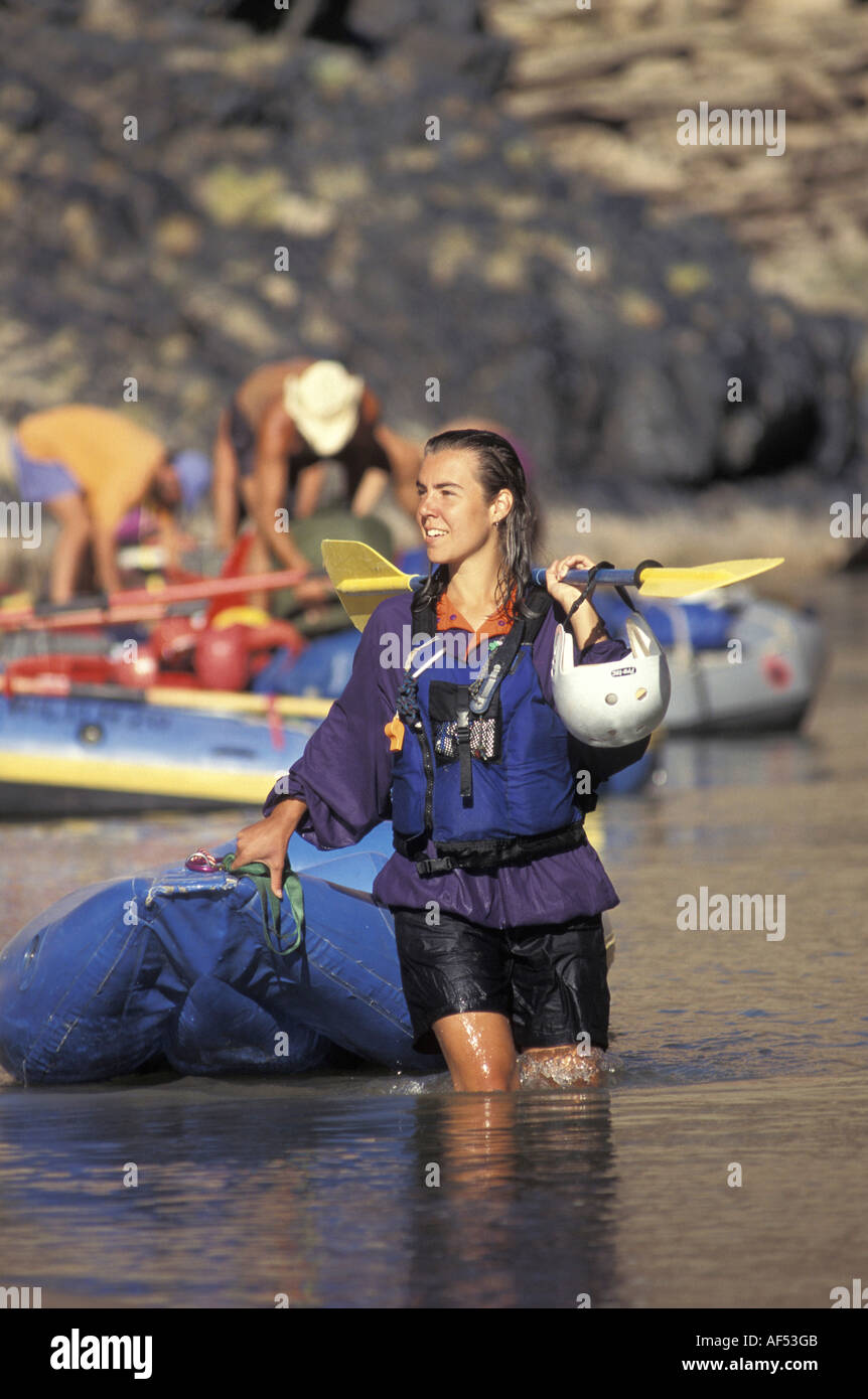 Young woman holding an inflatable raft and an oar Stock Photo - Alamy