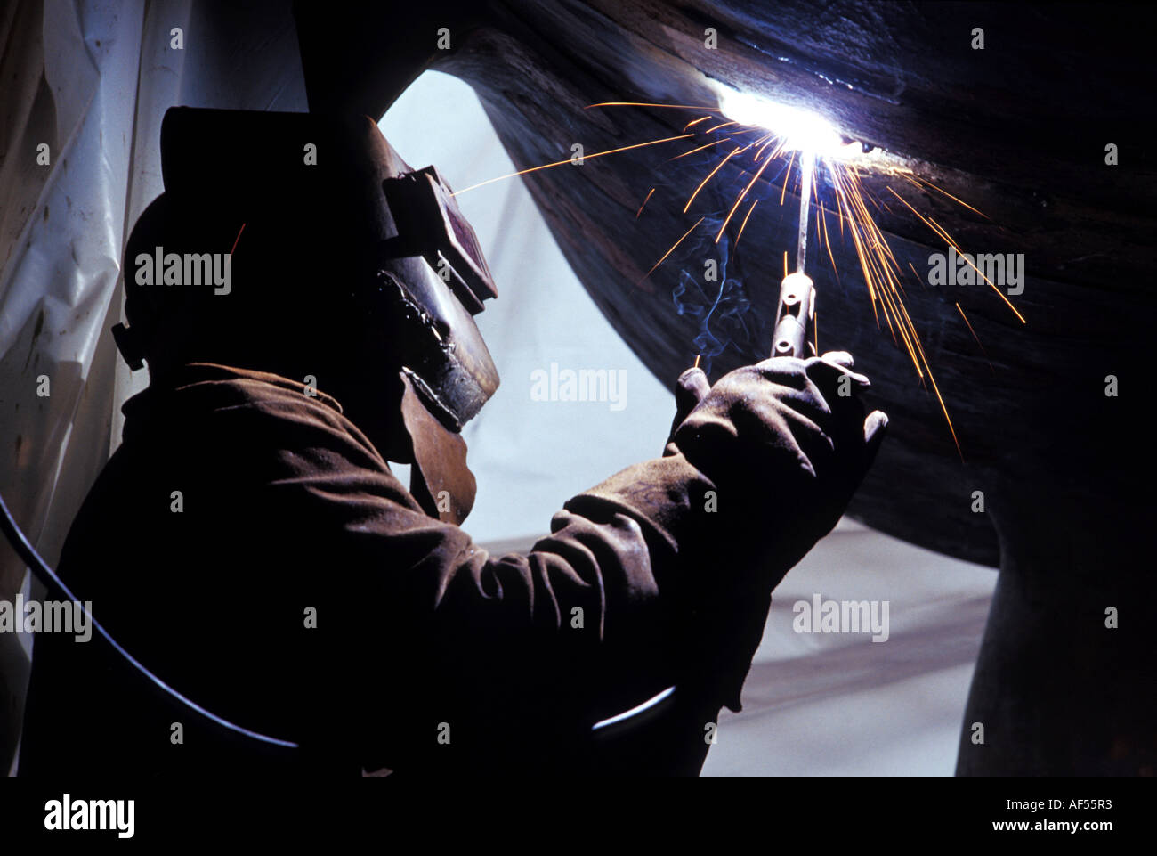 Side profile of a welder working with a welding torch Stock Photo - Alamy