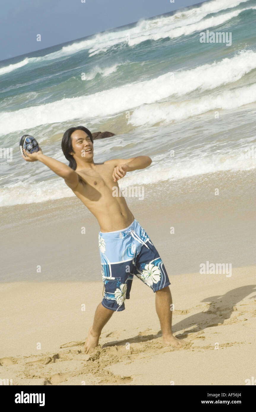 Young man throwing a ball on the beach Stock Photo - Alamy