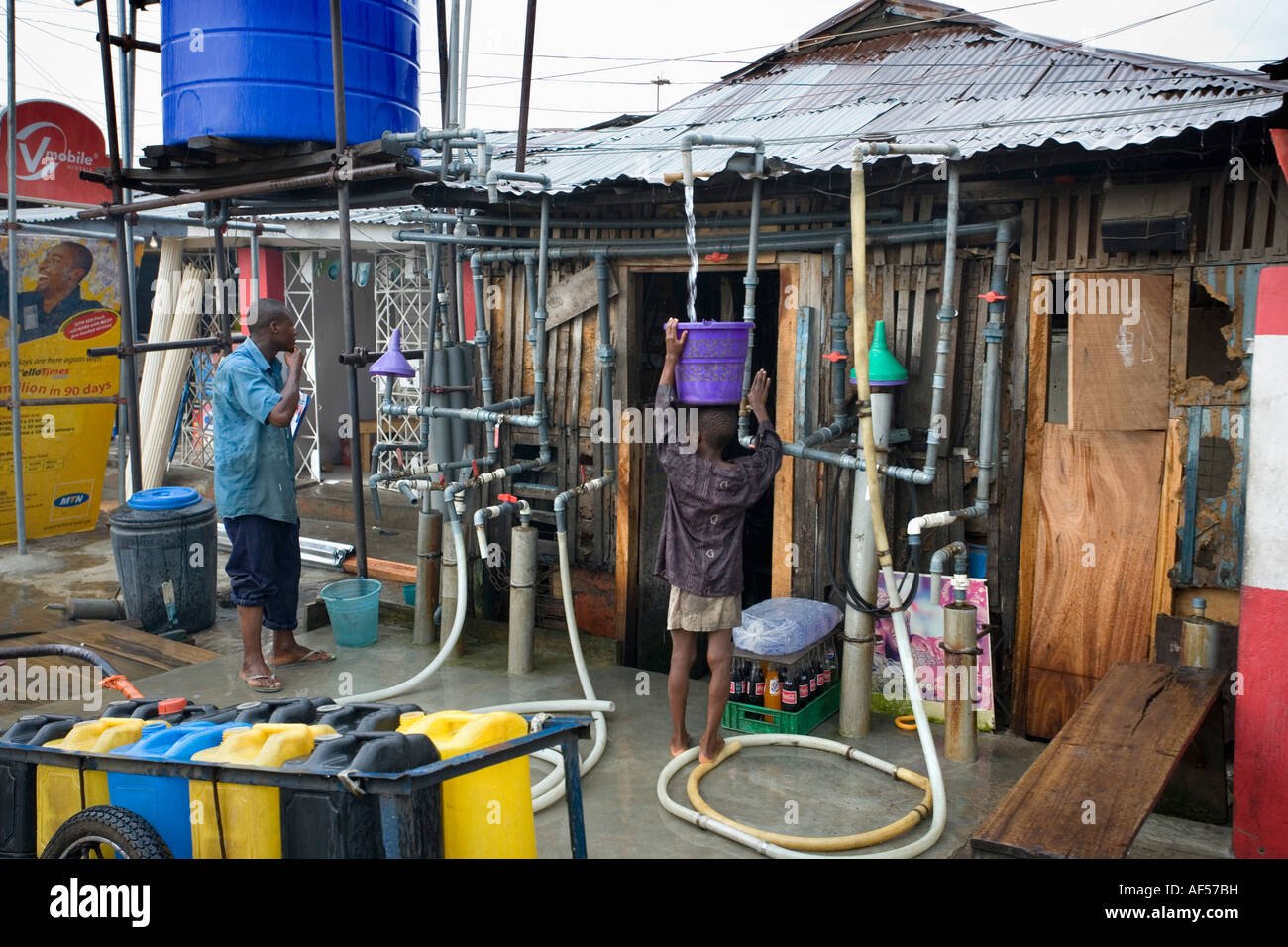 Nigeria Lagos Boy holding bucket on head. Oshidin district Stock Photo ...