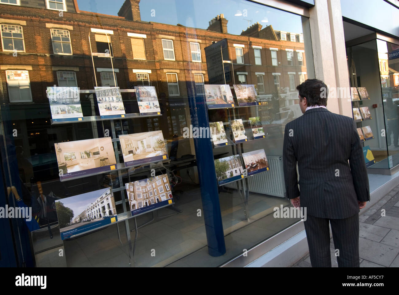 Man looking in estate agent window in London, UK Stock Photo - Alamy