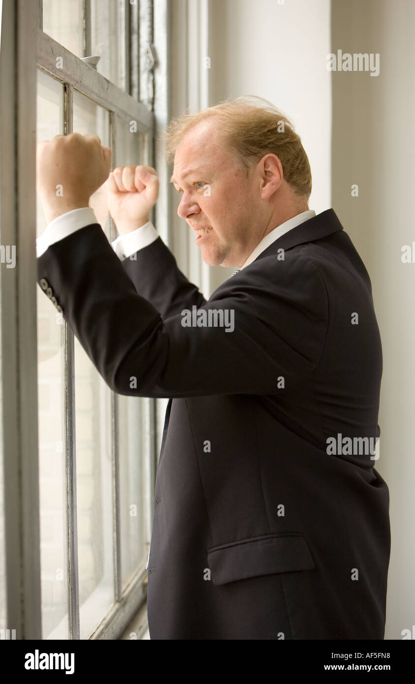 Business man banging on a window Stock Photo - Alamy