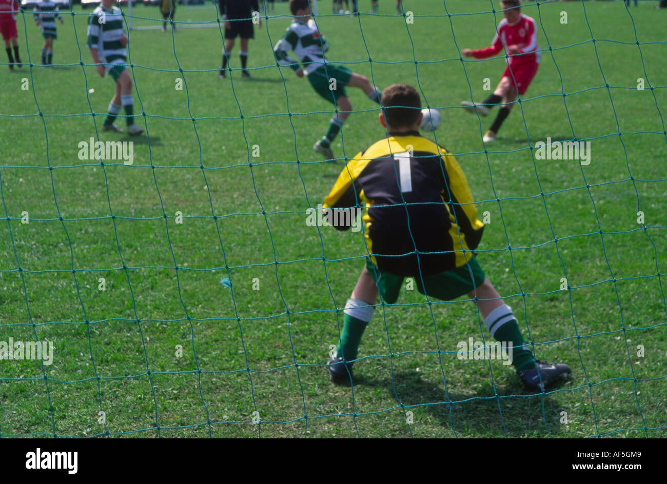 Children's football tournament. View of goalkeeper from behind the net ...