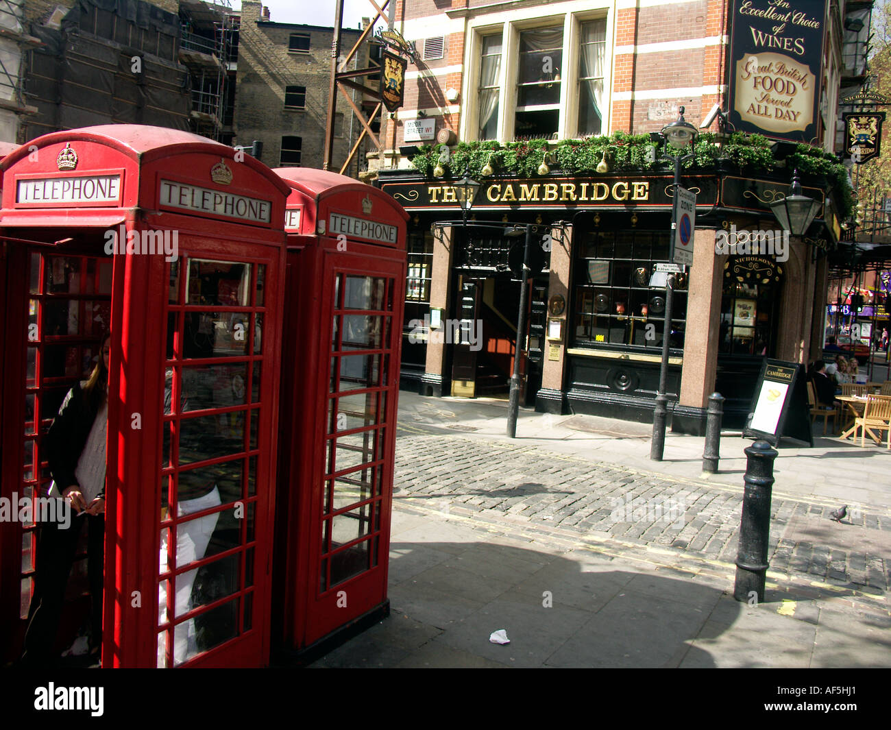 Traditional red phone boxes by the Cambridge pub Goodge Street London ...