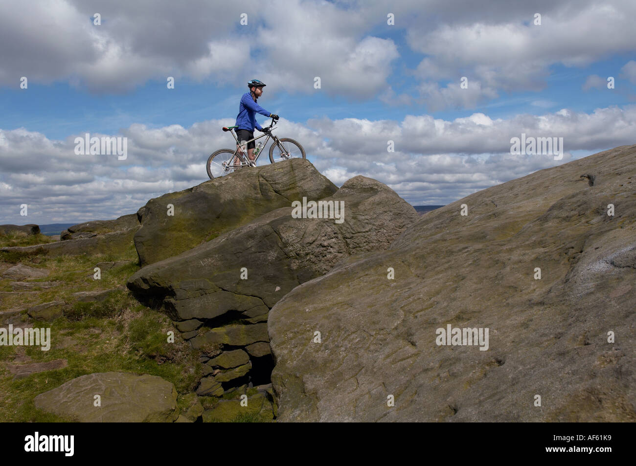 man in rural mountain dale type landscape on and riding a mountain bike ...