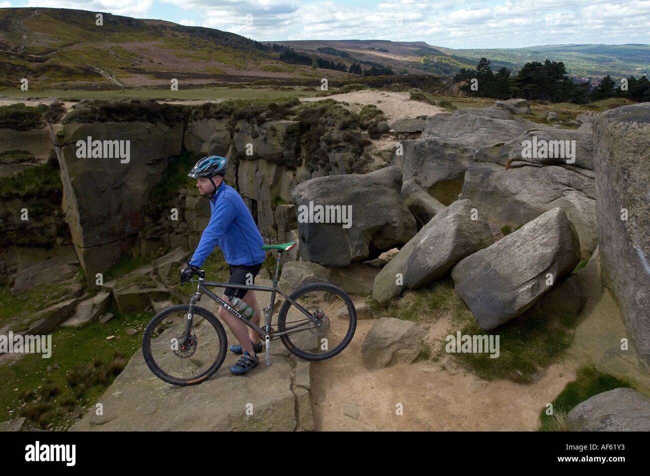 man in rural mountain dale type landscape on and riding a mountain bike ...