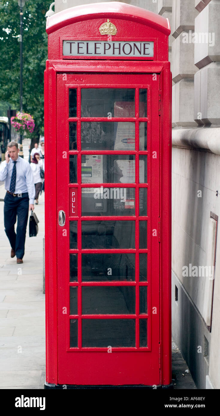Red Telephone Box in London with Man on Mobile Phone in Distance Stock ...