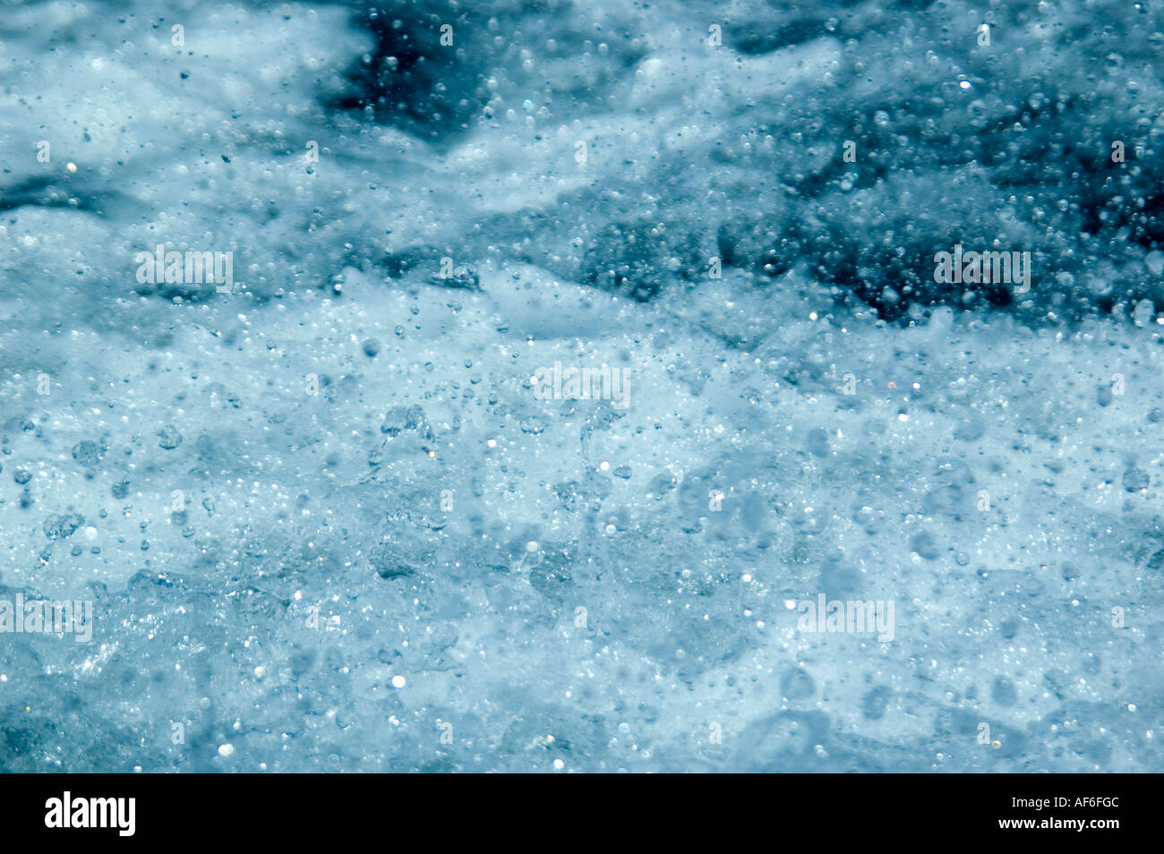 Horizontal close up of the surface of the blue sea being agitated and ...