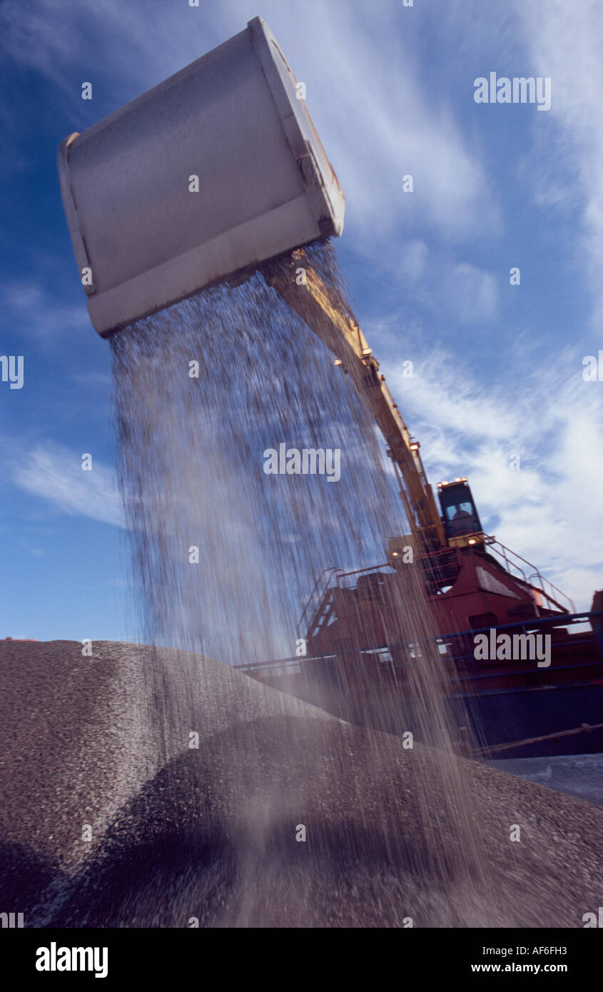 Excavator unloading gravel from a ship Stock Photo - Alamy