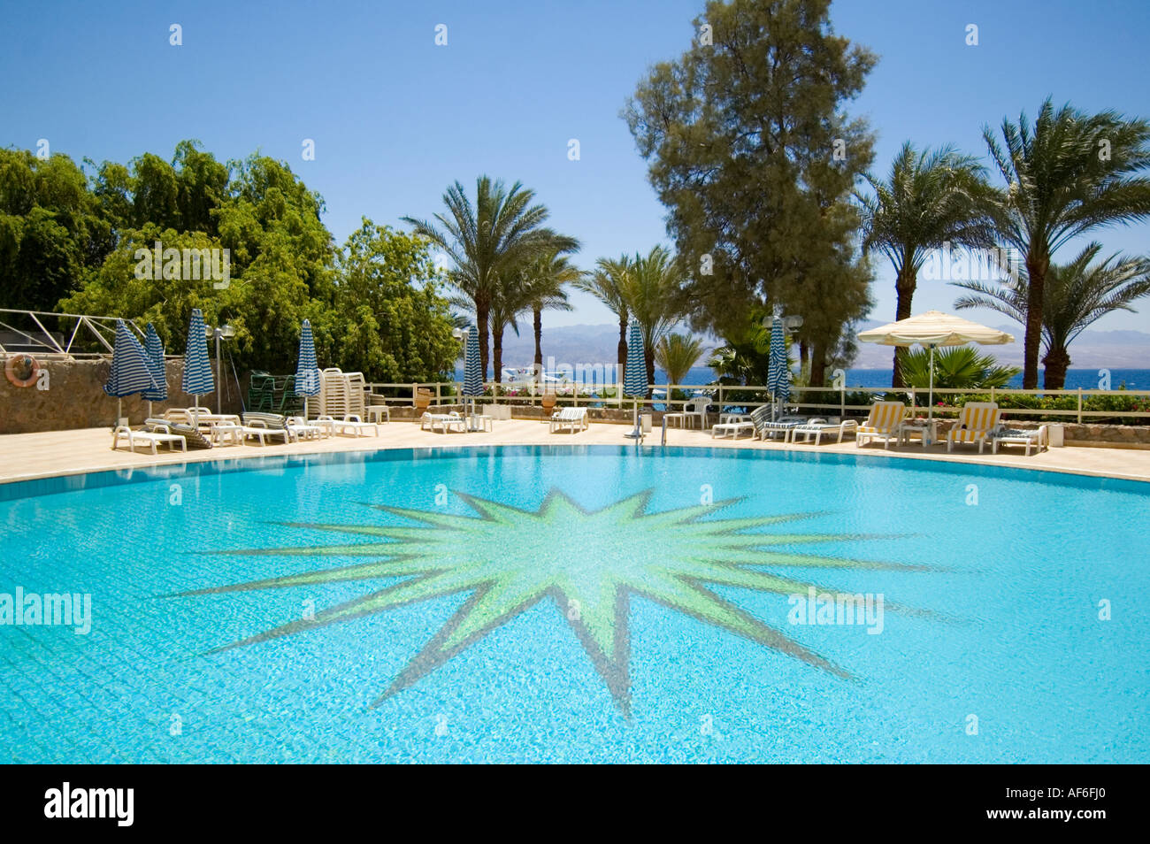 Horizontal wide angle of a deserted bright blue swimming pool ...