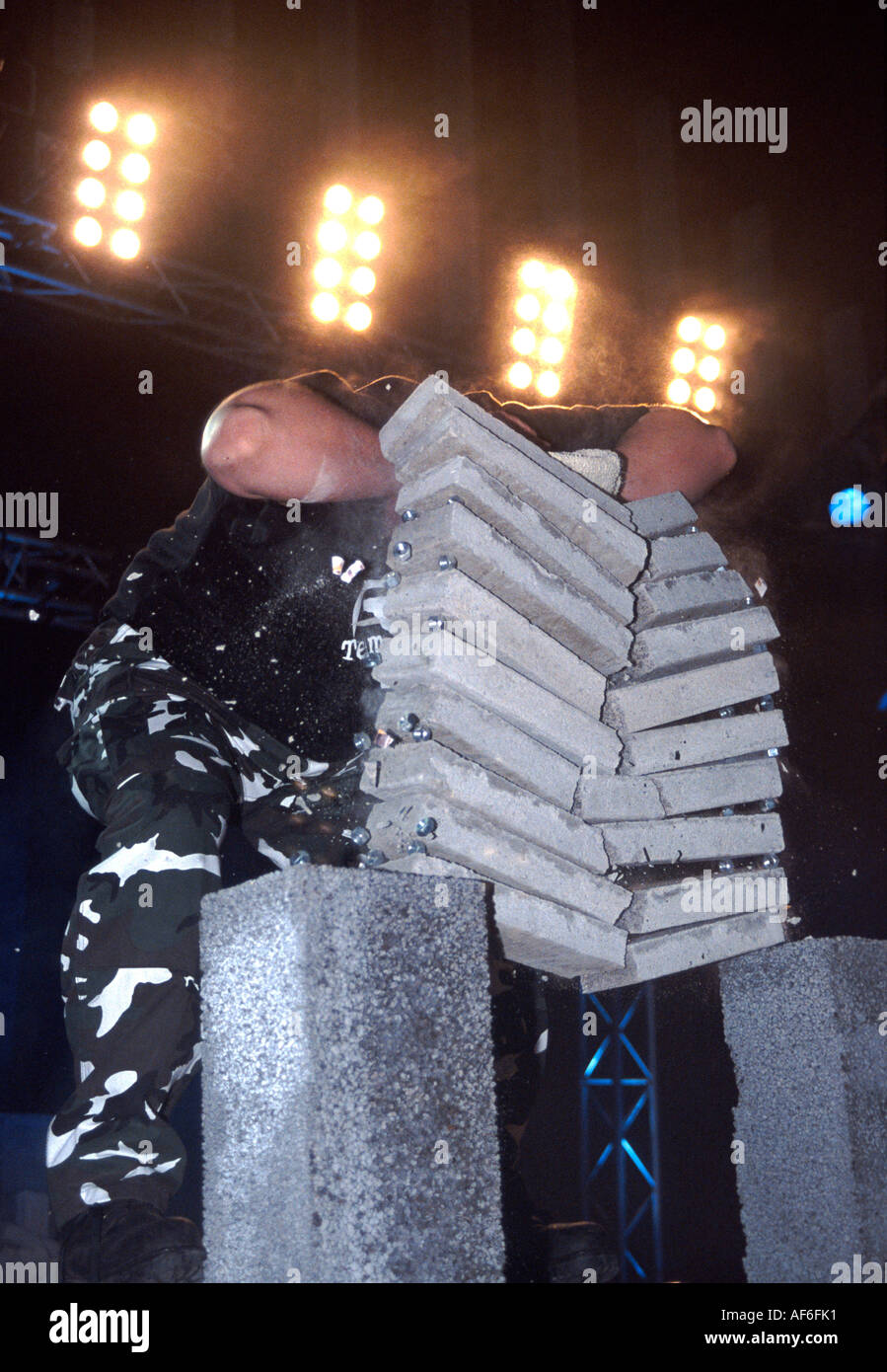 Performer breaking 10 bricks of concrete with his forehead Stock Photo ...