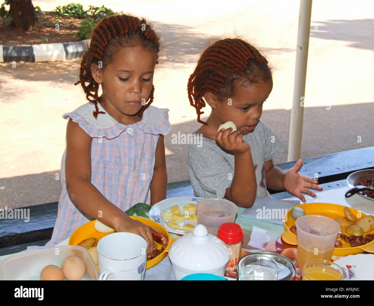 Two young girls eating breakfast Stock Photo - Alamy