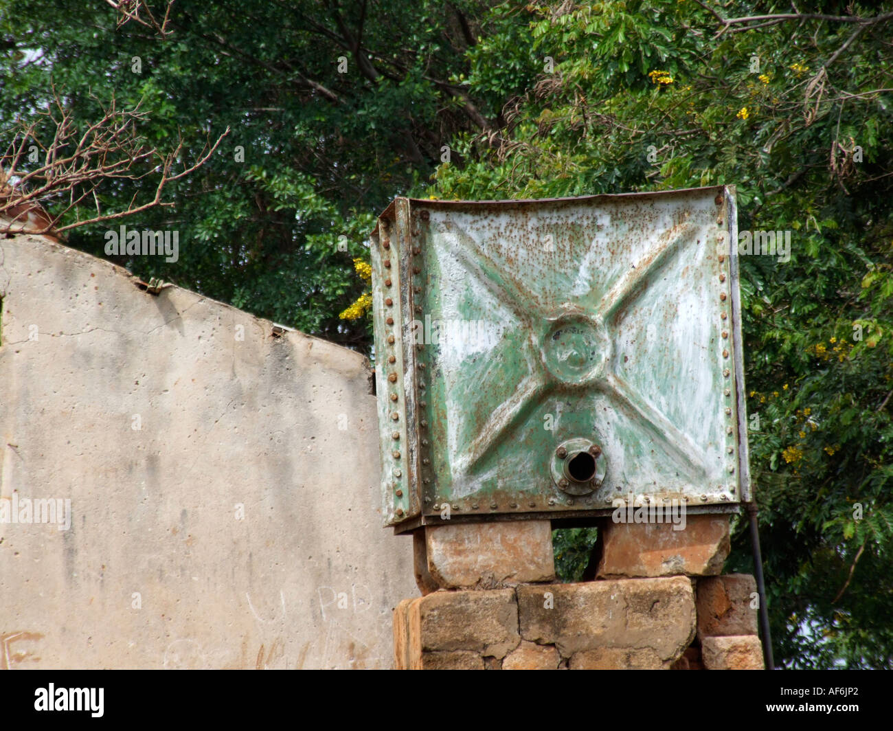 Old water tank by a wall Stock Photo - Alamy