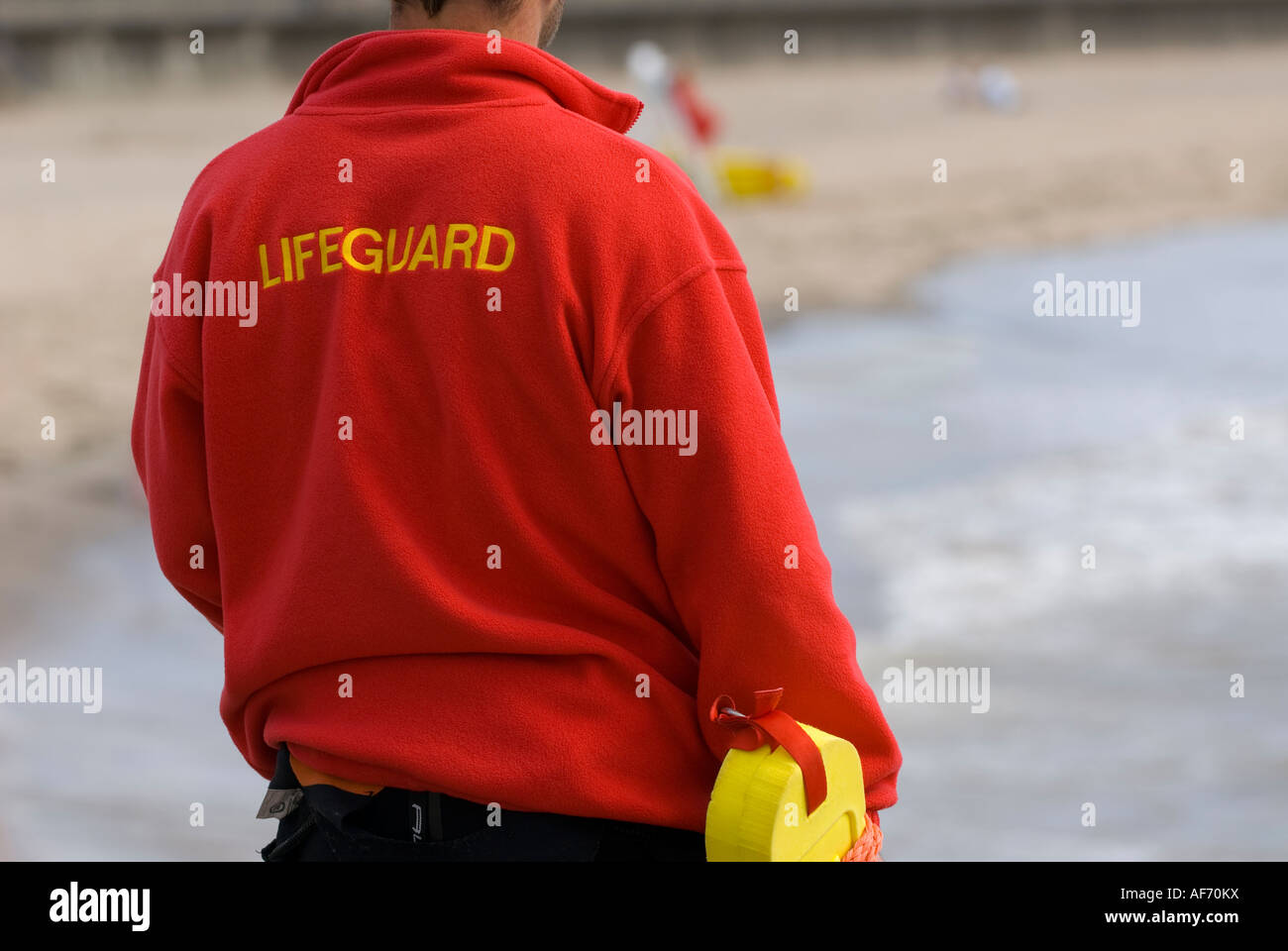 Lifeguard standing watching on North Antrim coast Northern Ireland ...