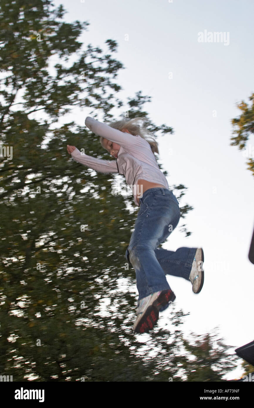 Young girl child getting exercise jumping outdoors with element of risk ...
