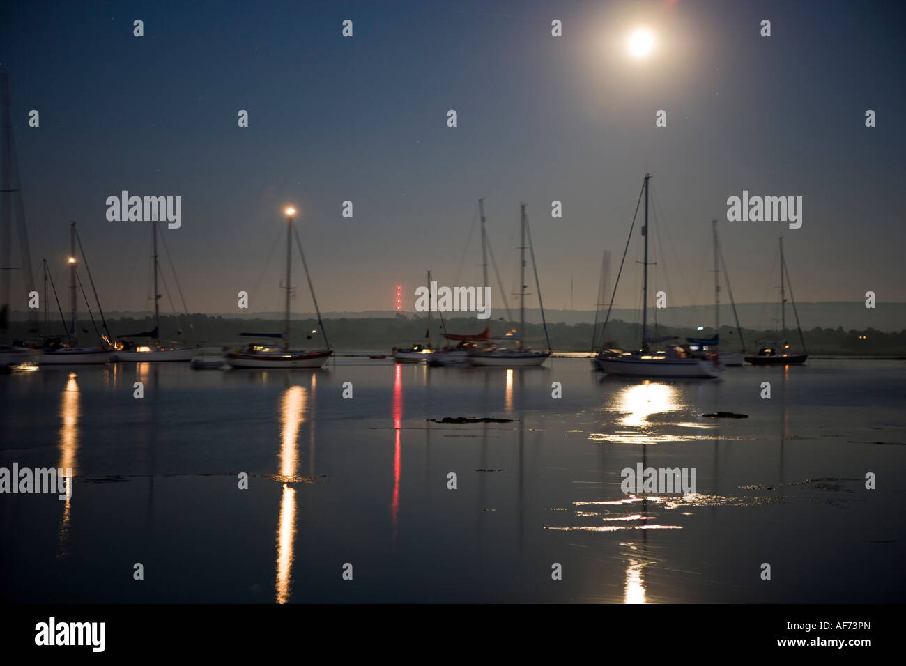 Yachts anchored in Newtown Creek Isle of Wight illuminated by moonlight ...