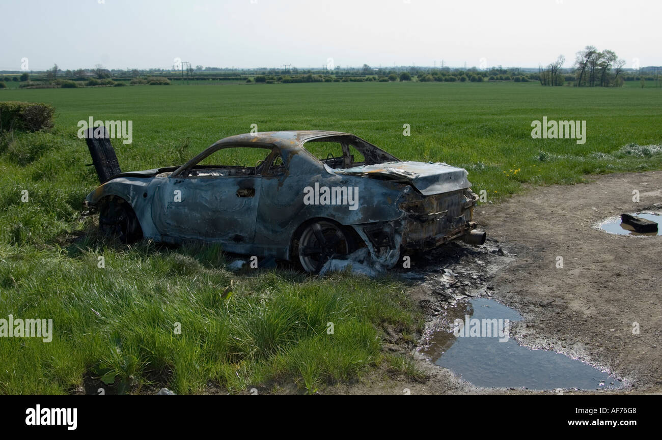 Burnt out BMW sports car on a country Lane Stock Photo - Alamy