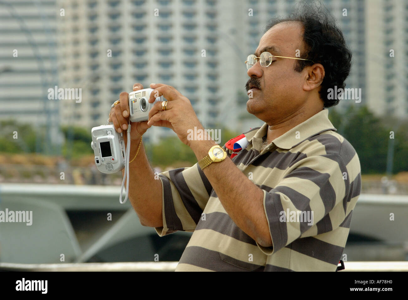 Indian man photographing with digital cameras, Singapore Stock Photo ...