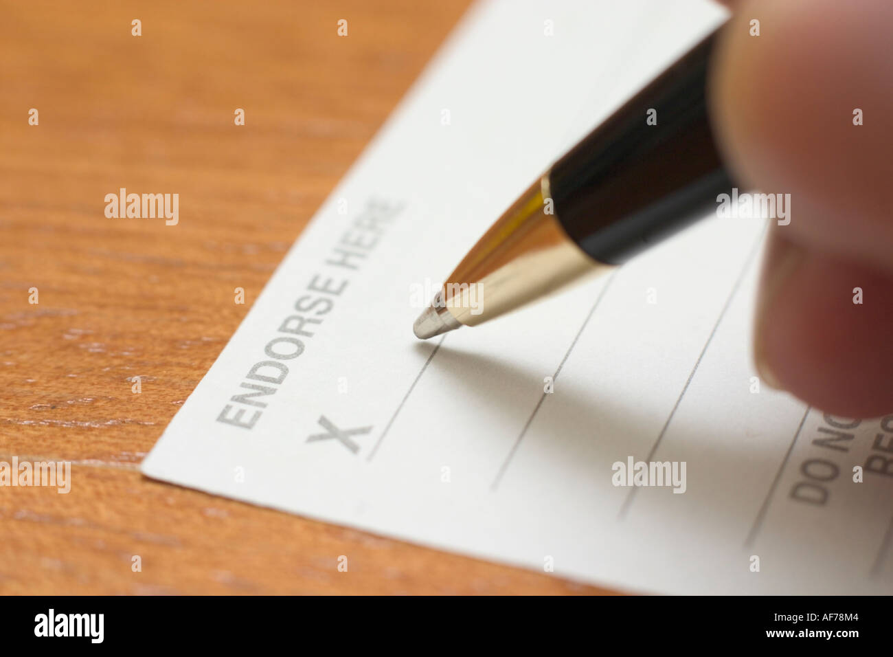 pen signing endorse here column behind a piece of cheque Stock Photo ...